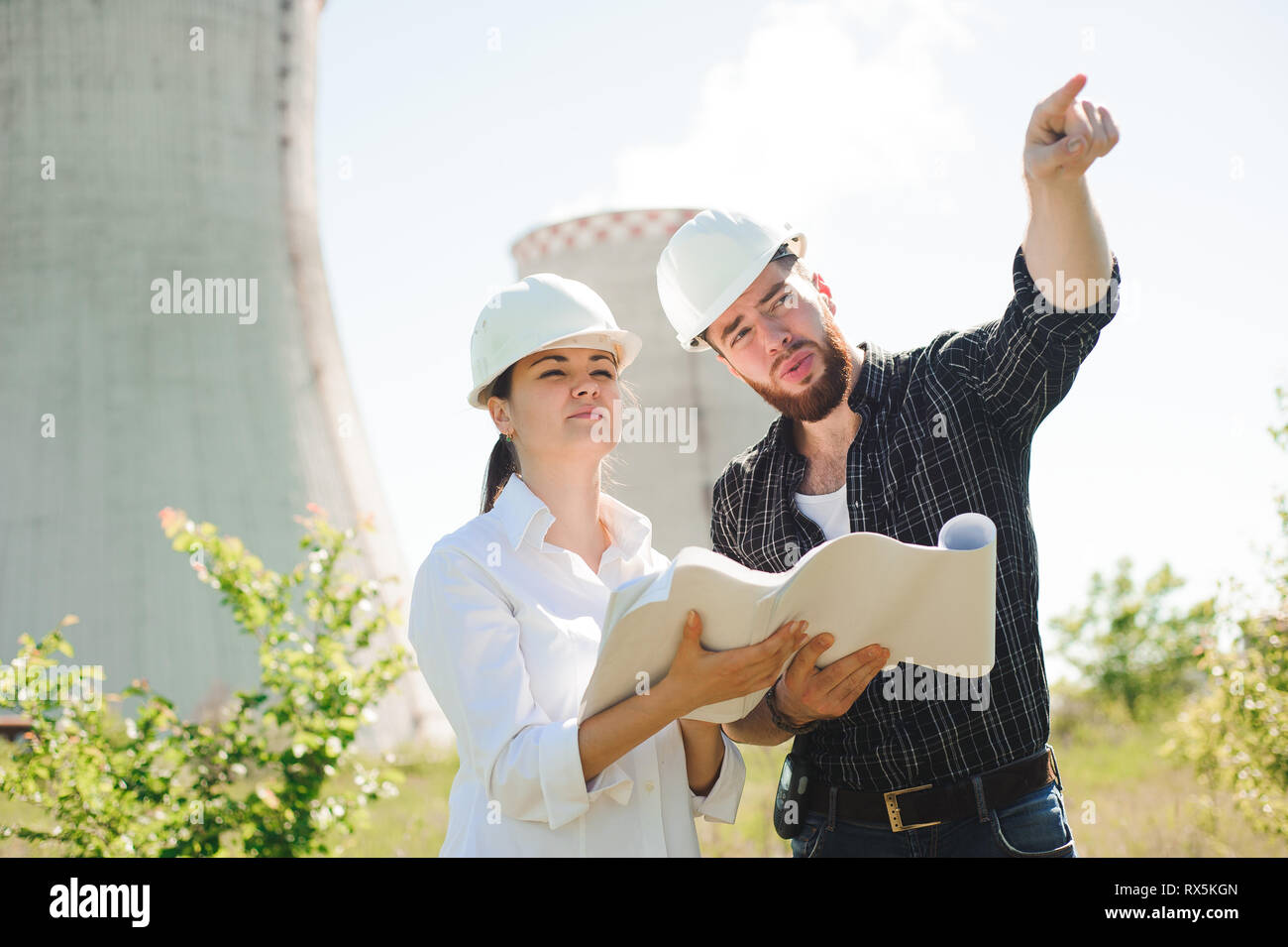 two engineers standing at electricity station, discussing plan Stock ...
