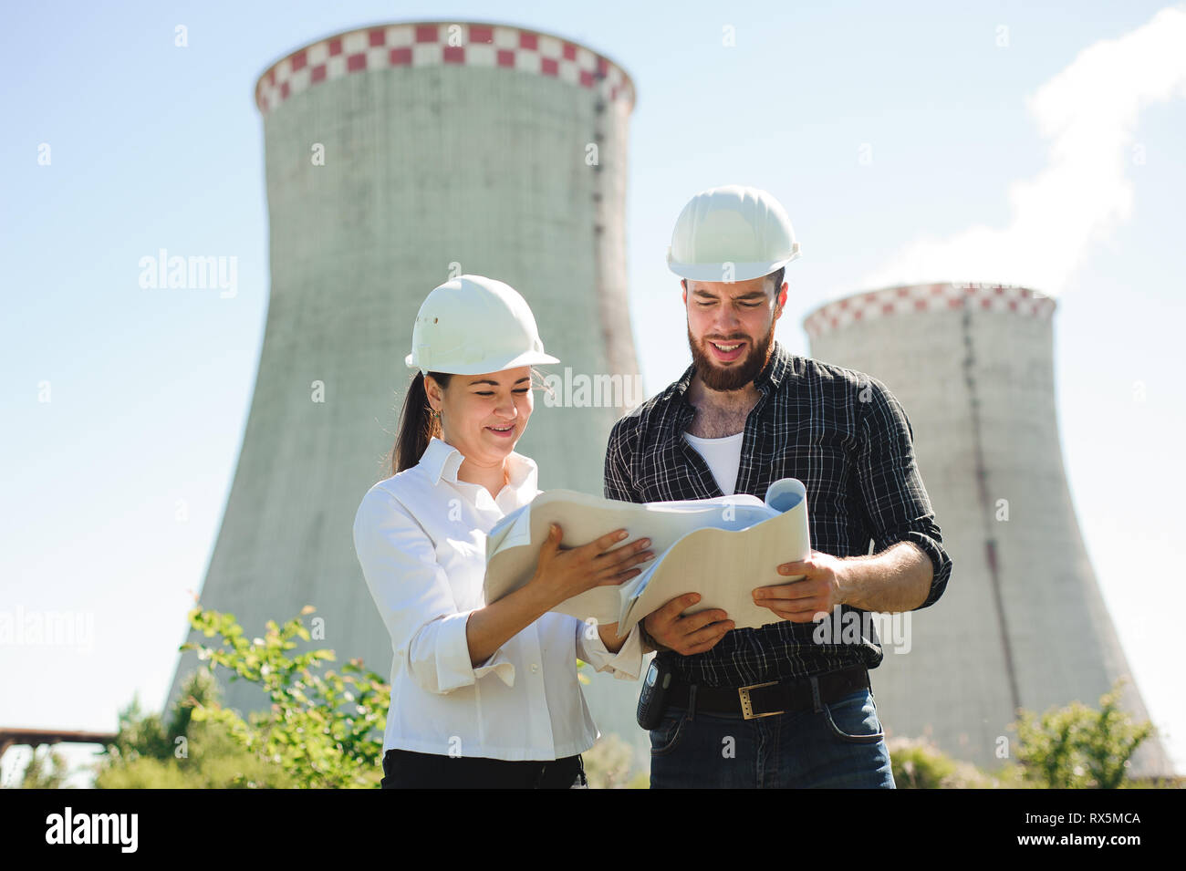 two engineers standing at electricity station, discussing plan Stock ...