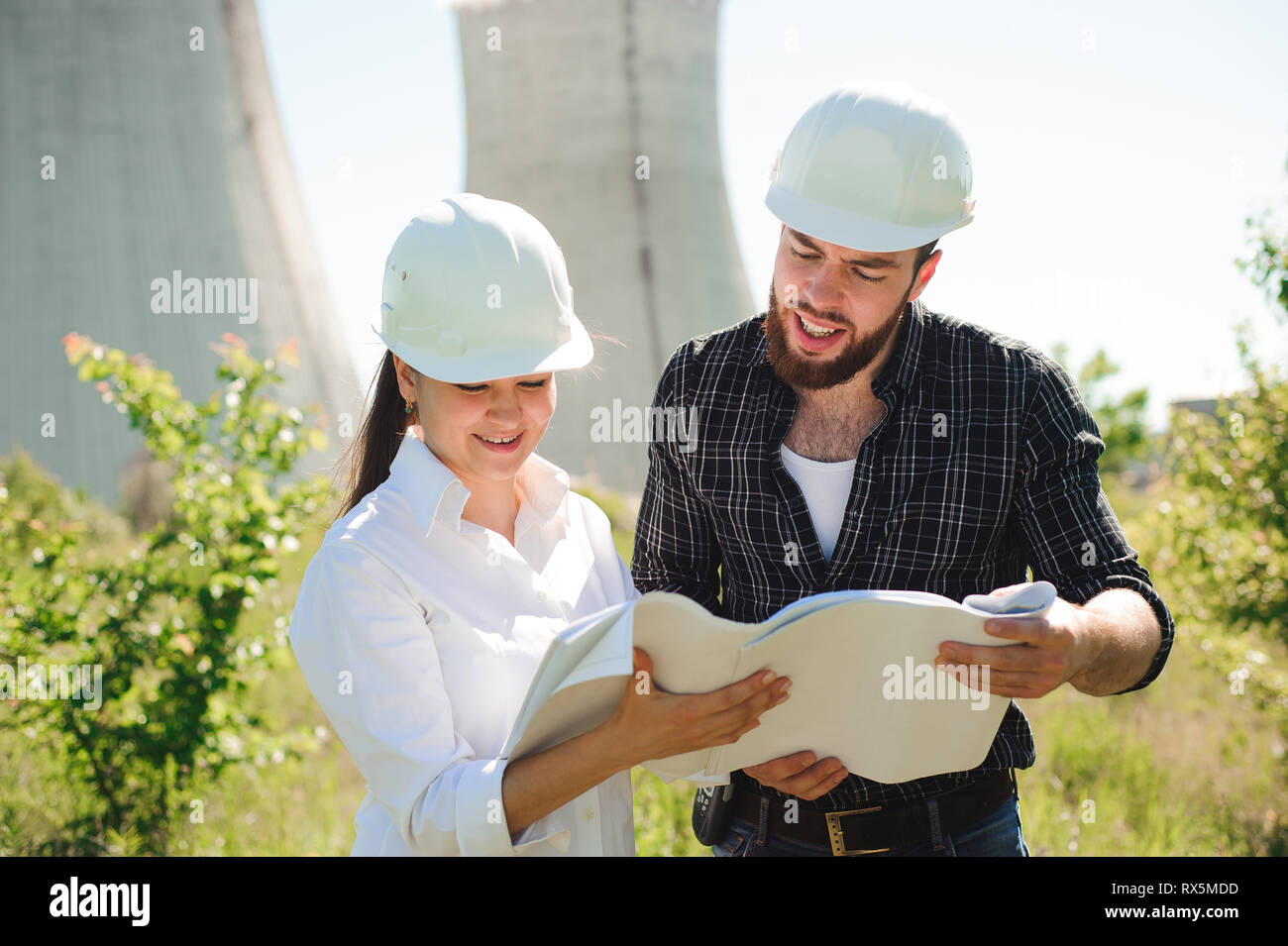 two engineers standing at electricity station, discussing plan Stock ...