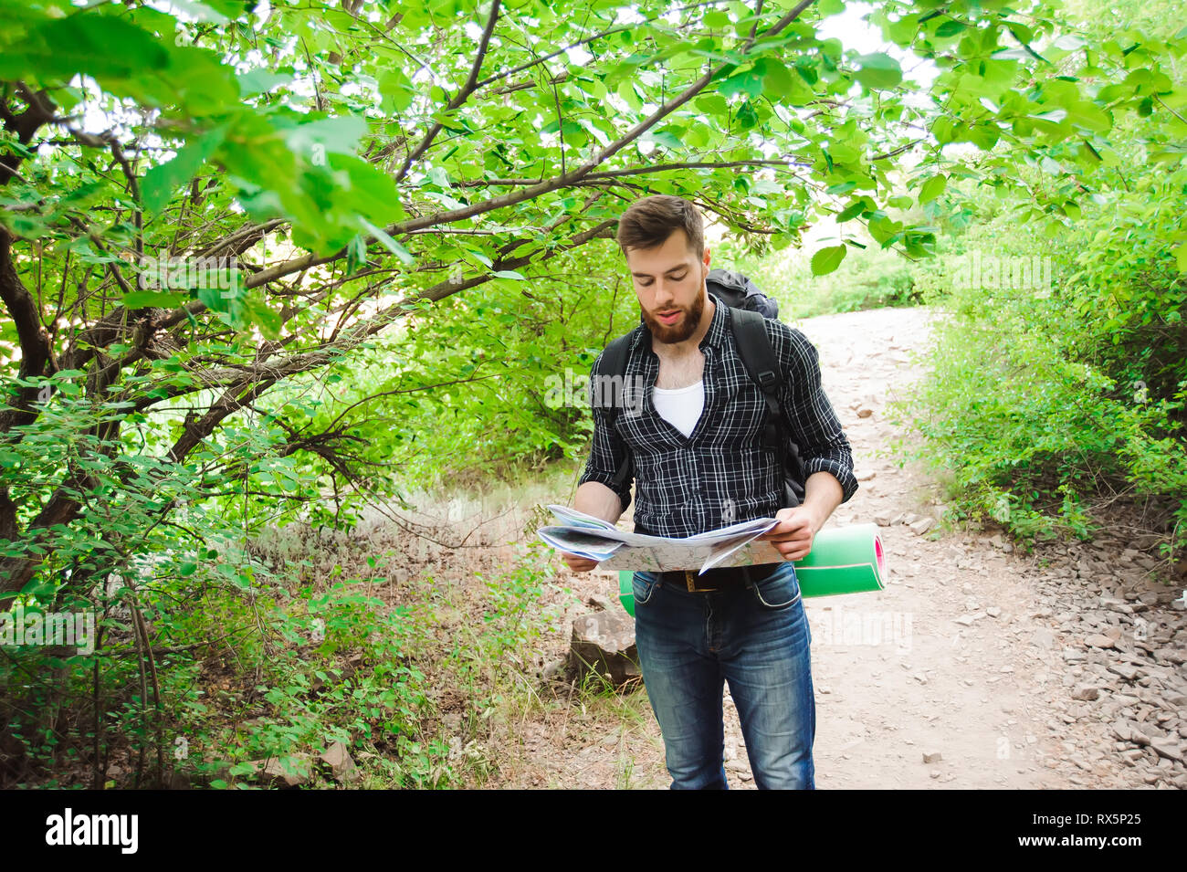 Young Man Traveler with map backpack relaxing outdoor on background ...