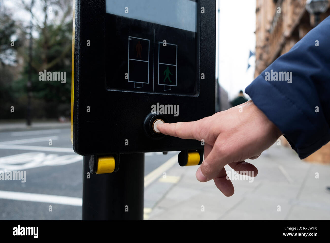 closeup of a caucasian man pushing a pedestrian call button in a ...