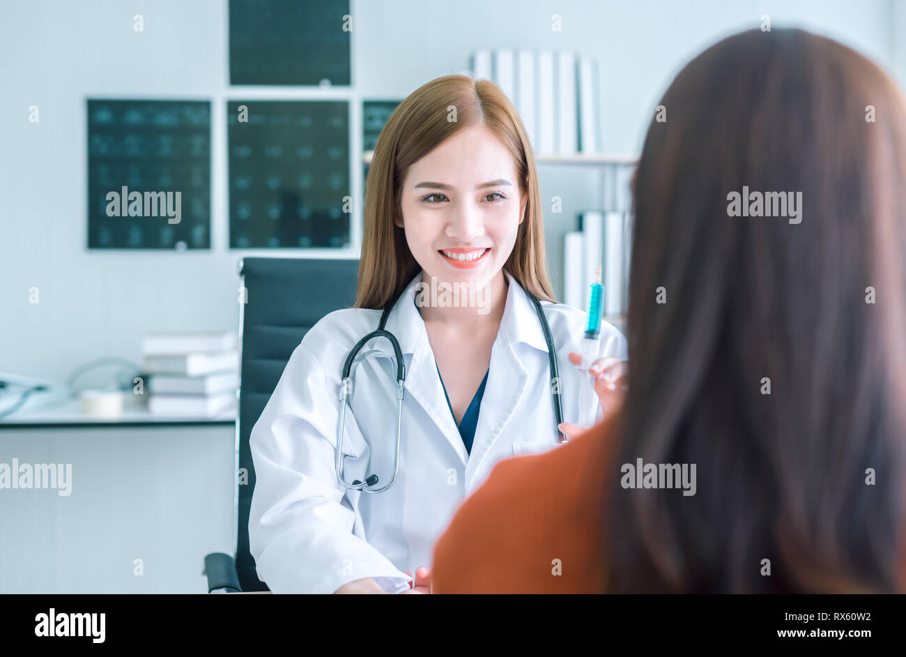 Young asian doctor showing hand press syringe ready to inject shot ...