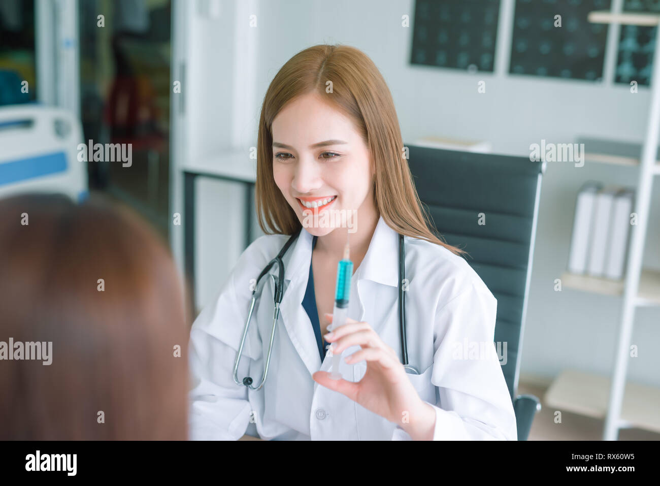 Young asian doctor showing hand press syringe ready to inject shot ...