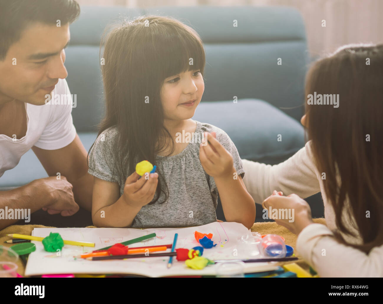Portrait of happy family daughter girl is learning to use colorful play ...
