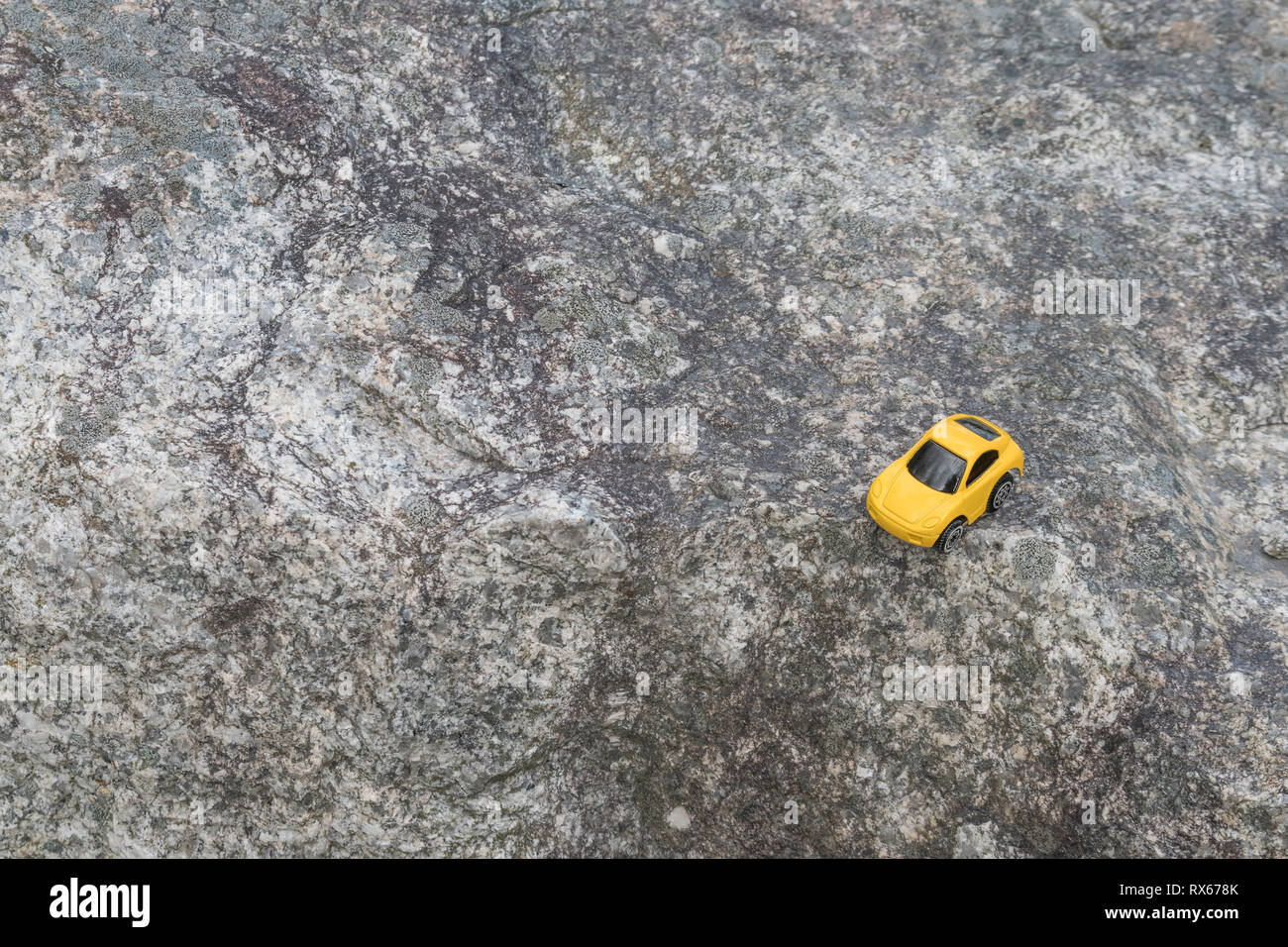 Yellow toy car falling off edge of outcrop. For falling off cliff edge ...