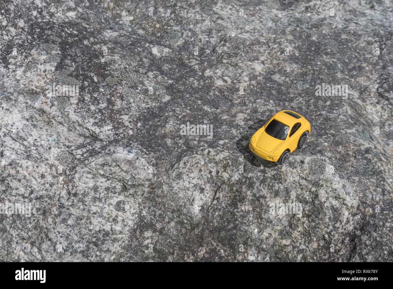 Yellow toy car falling off edge of outcrop. For falling off cliff edge ...