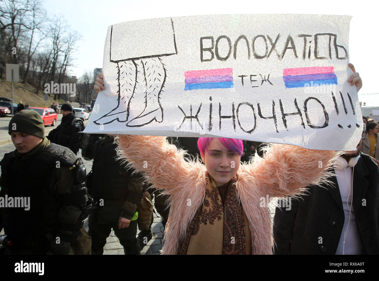 A protester is seen holding a placard saying Hairiness is also feminine ...