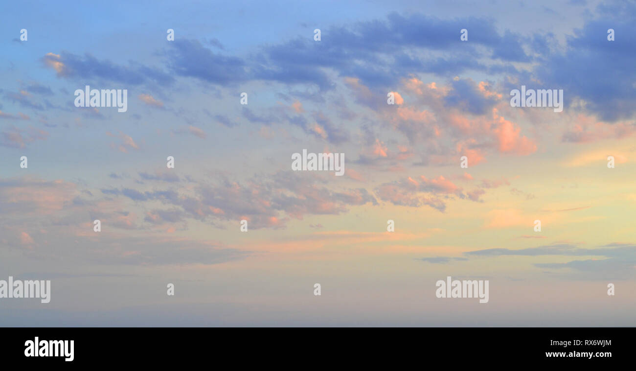 Light pink, blue and yellow clouds in the sunset sky in Summer Stock ...
