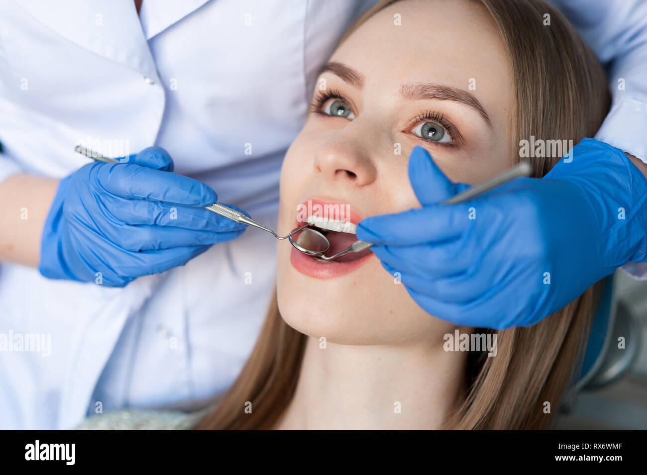Dentist examining a patient's teeth in the dental clinic Stock Photo ...