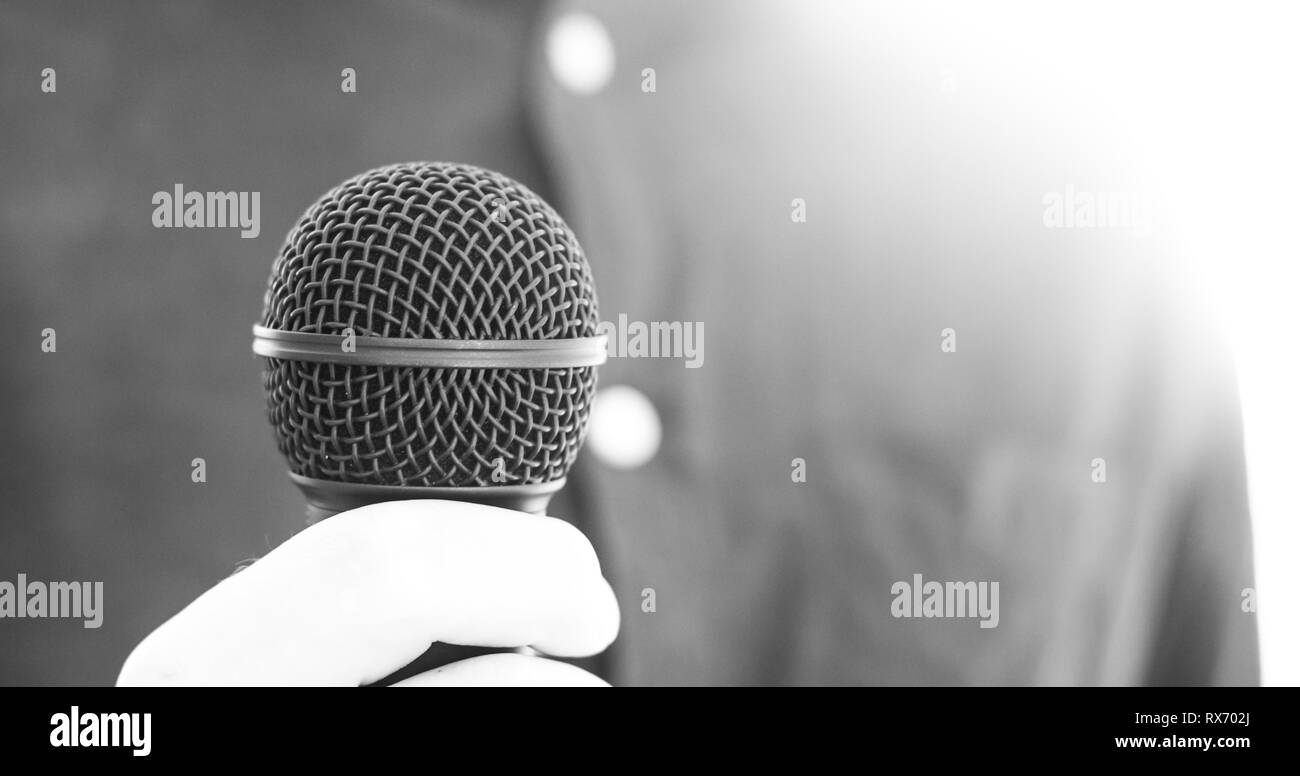 Interview: Black microphone in the foreground, man with blue shirt in ...