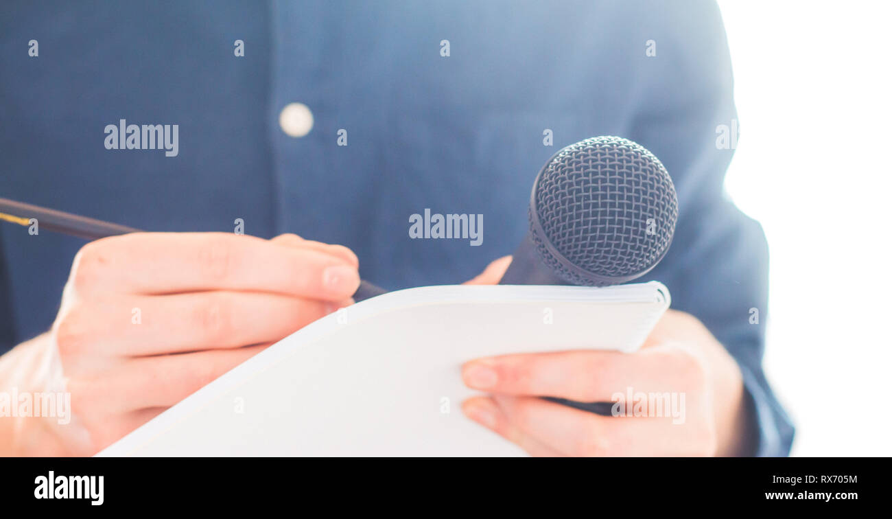 Cut-out of a male journalist in a blue shirt at a news conference who ...