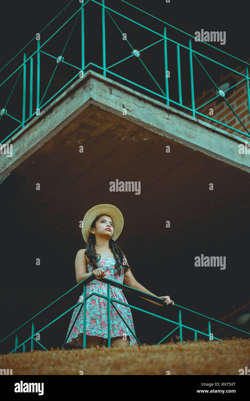 Young woman looking through a balcony Stock Photo - Alamy