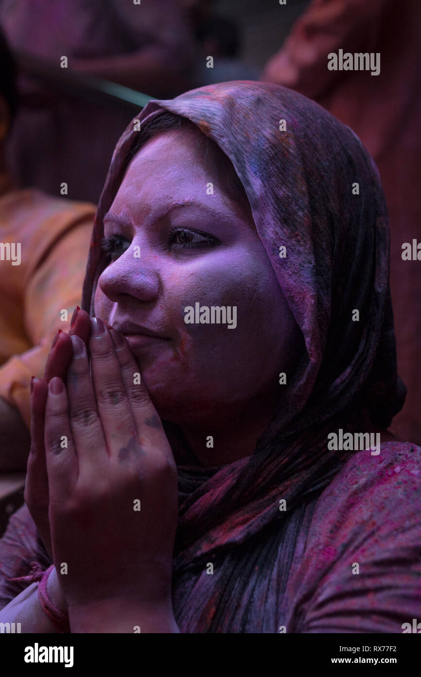 A woman with her face covered with colored powder during Holi festival ...