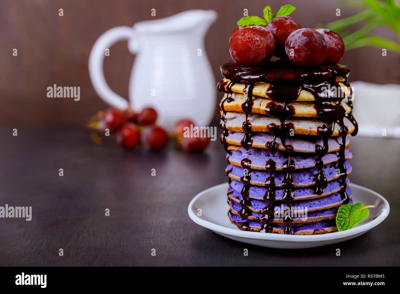 Beautiful pancakes with grape, chocolate glaze and mint with syrup ...