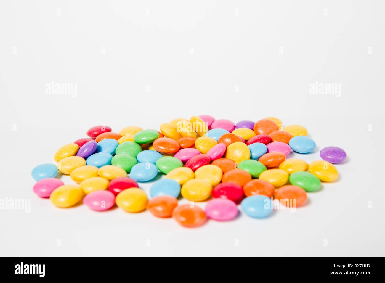 Pile of colorful sweets candies, side view - white background Stock ...
