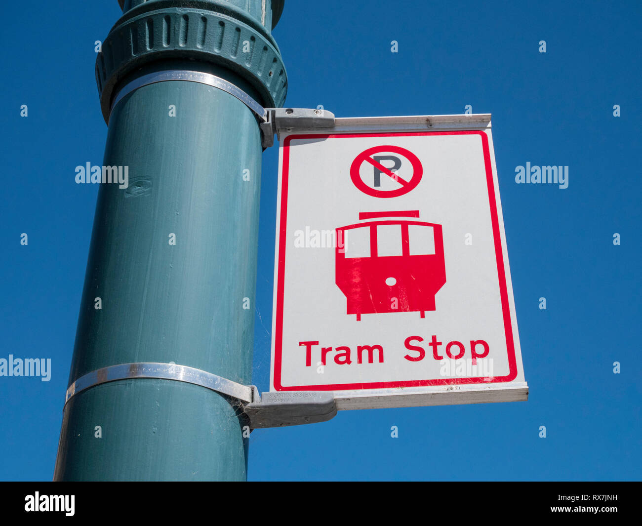 A red tram stop sign against a blue sky in Christchurch New Zealand ...