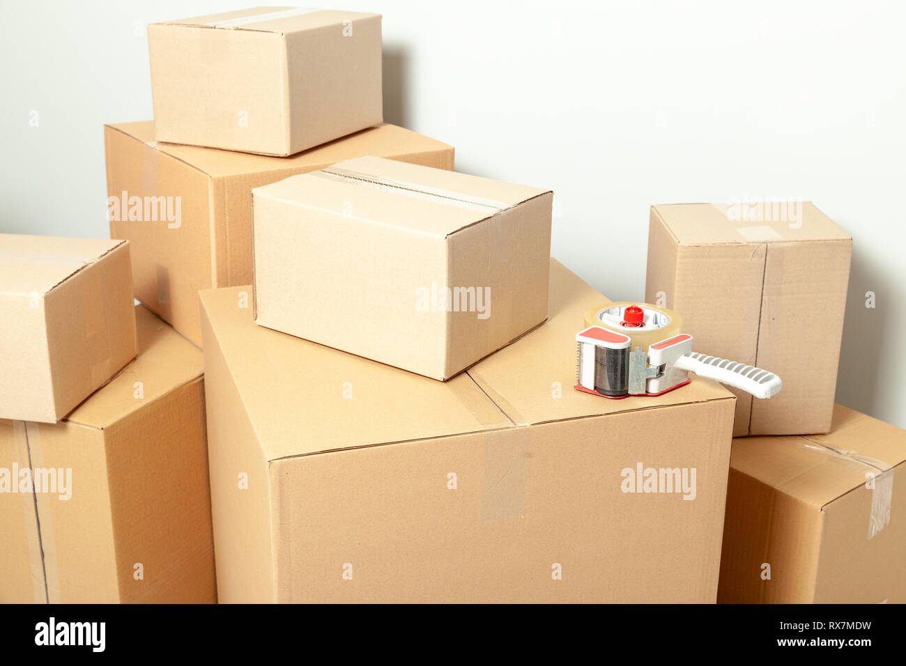 Day moving. Cardboard boxes on gray wall background Stock Photo - Alamy