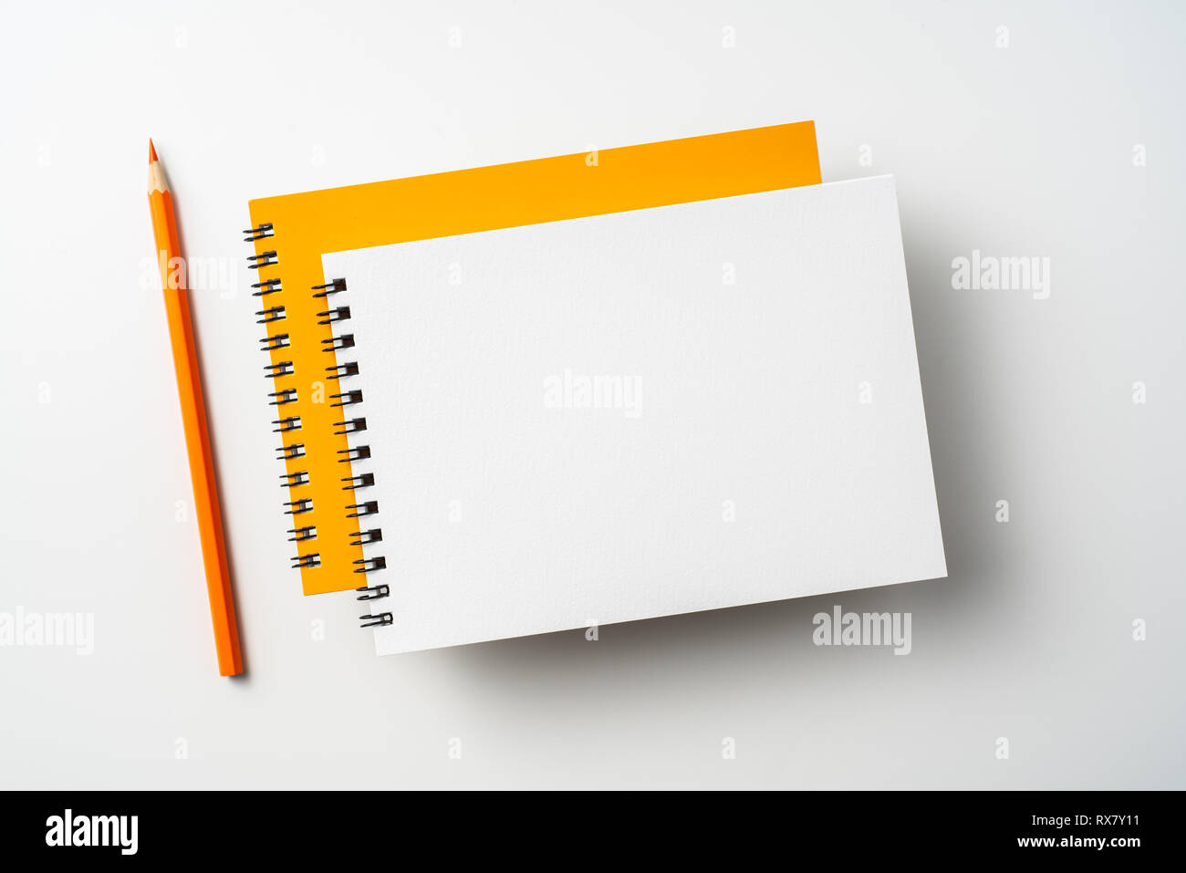 Design concept - Top view of two spiral orange notebook and pen ...