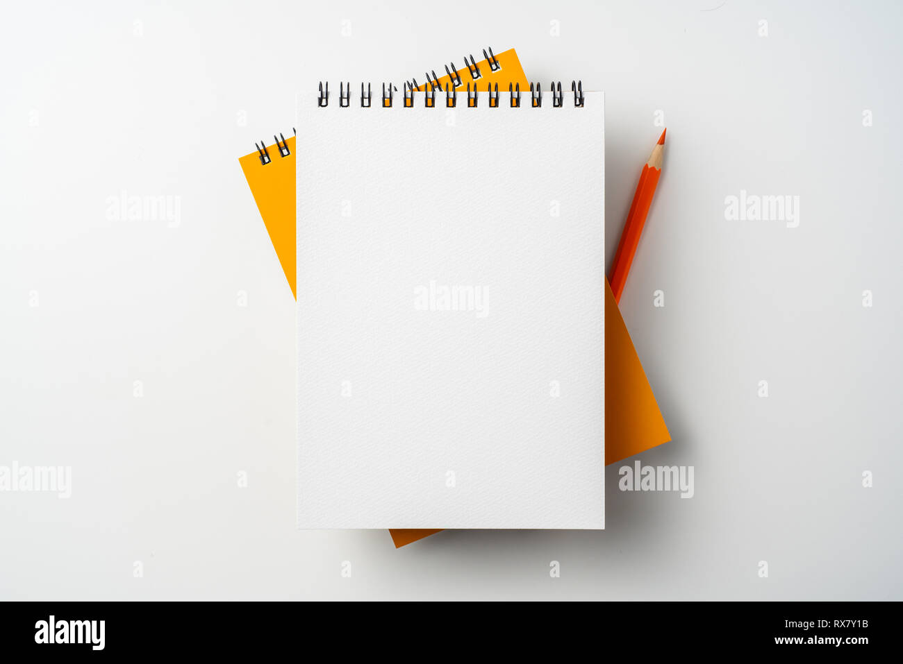 Design concept - Top view of two spiral orange notebook and pen ...