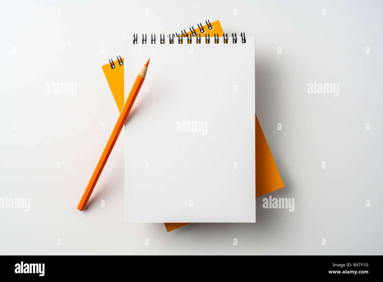 Design concept - Top view of two spiral orange notebook and pen ...
