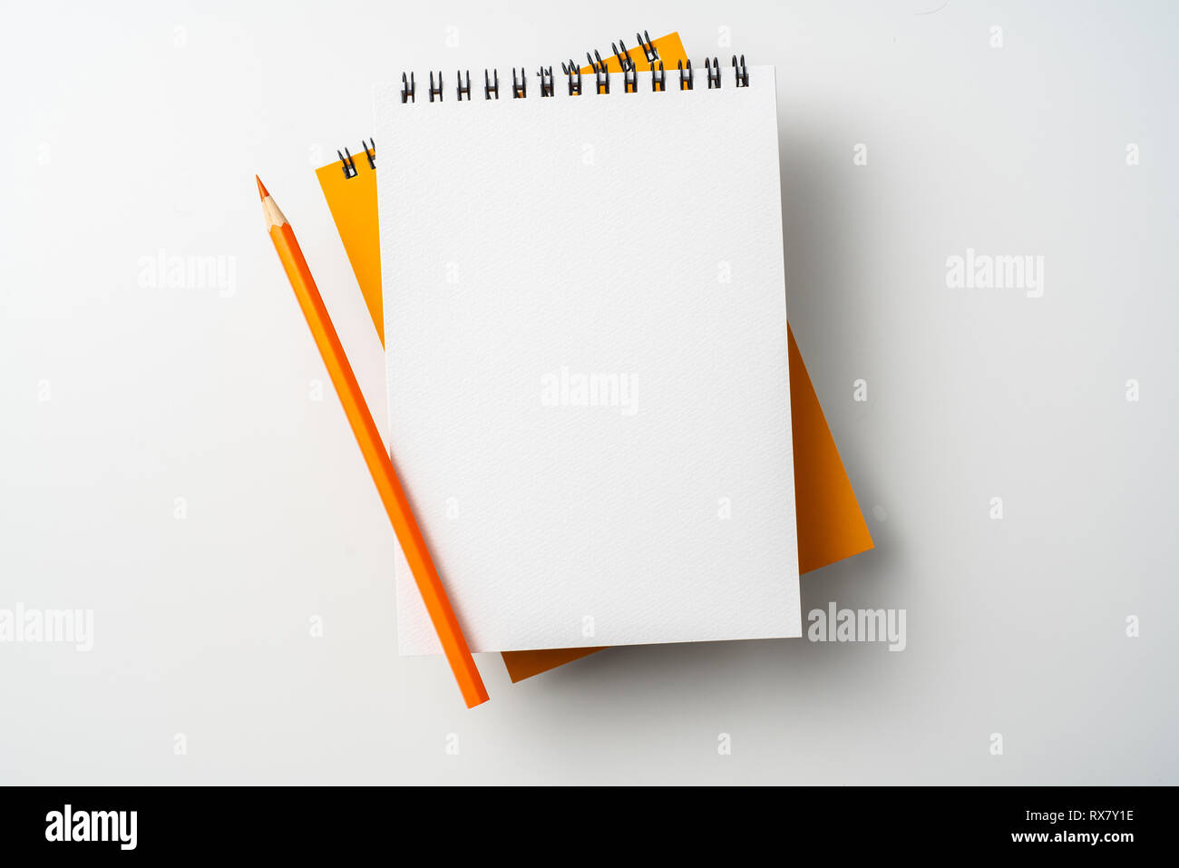 Design concept - Top view of two spiral orange notebook and pen ...