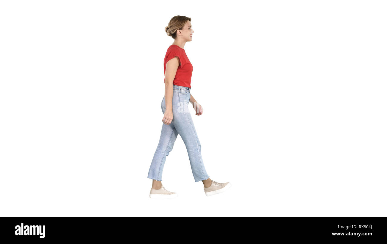 Full length shot. Side view. Woman in red t-shirt, jeans and sneakers ...