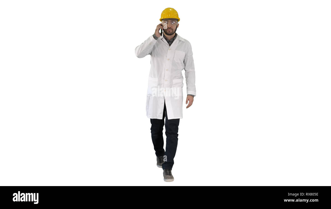 Full length portrait. Confident male engineer wearing helmet on call on ...