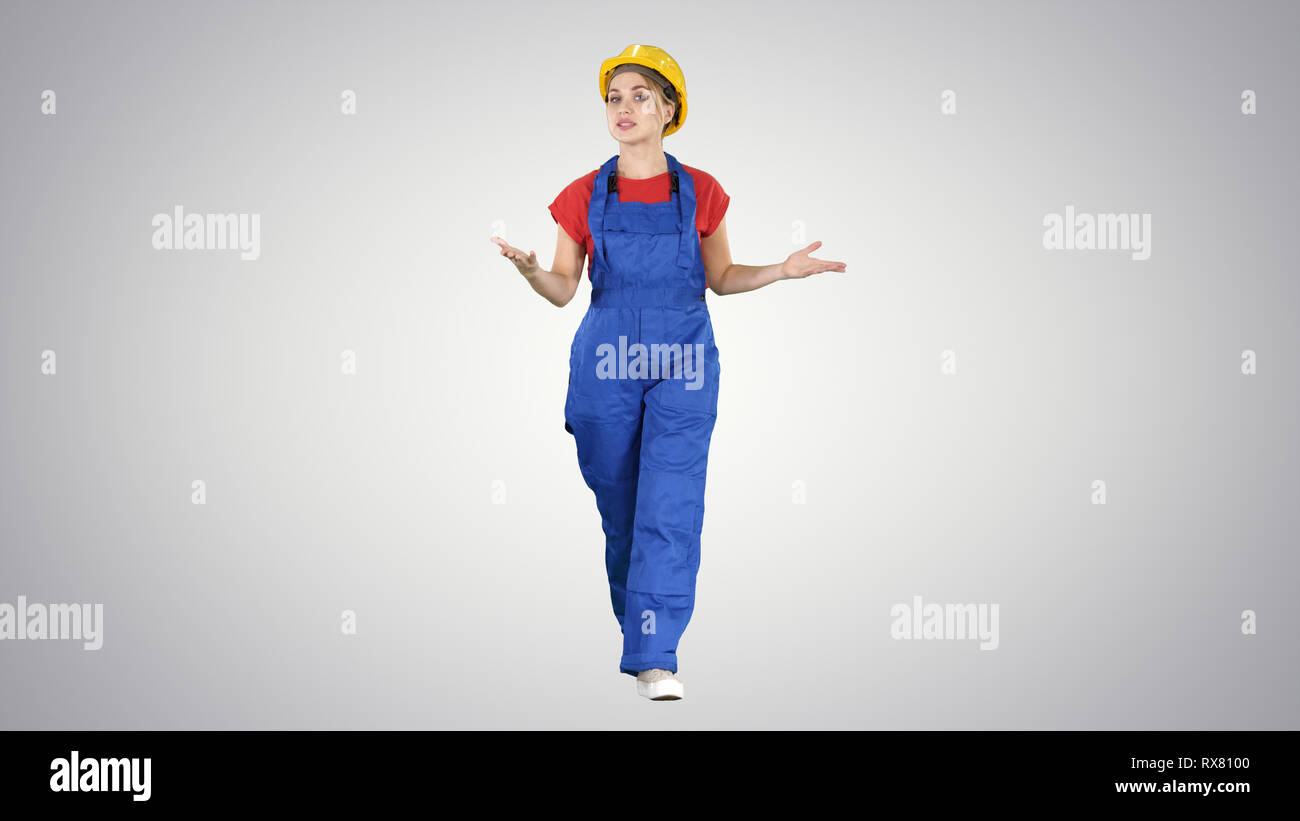 Full length shot. Cheerful female construction worker talking to camera ...