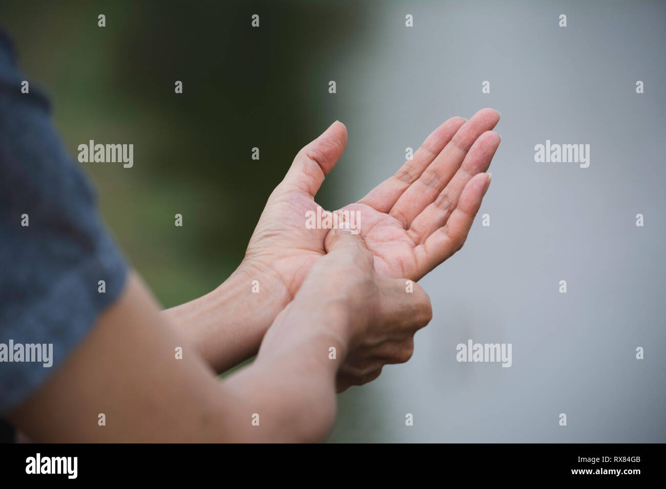 Woman holding her hand. Pain in a woman hand. Female massaging painful ...