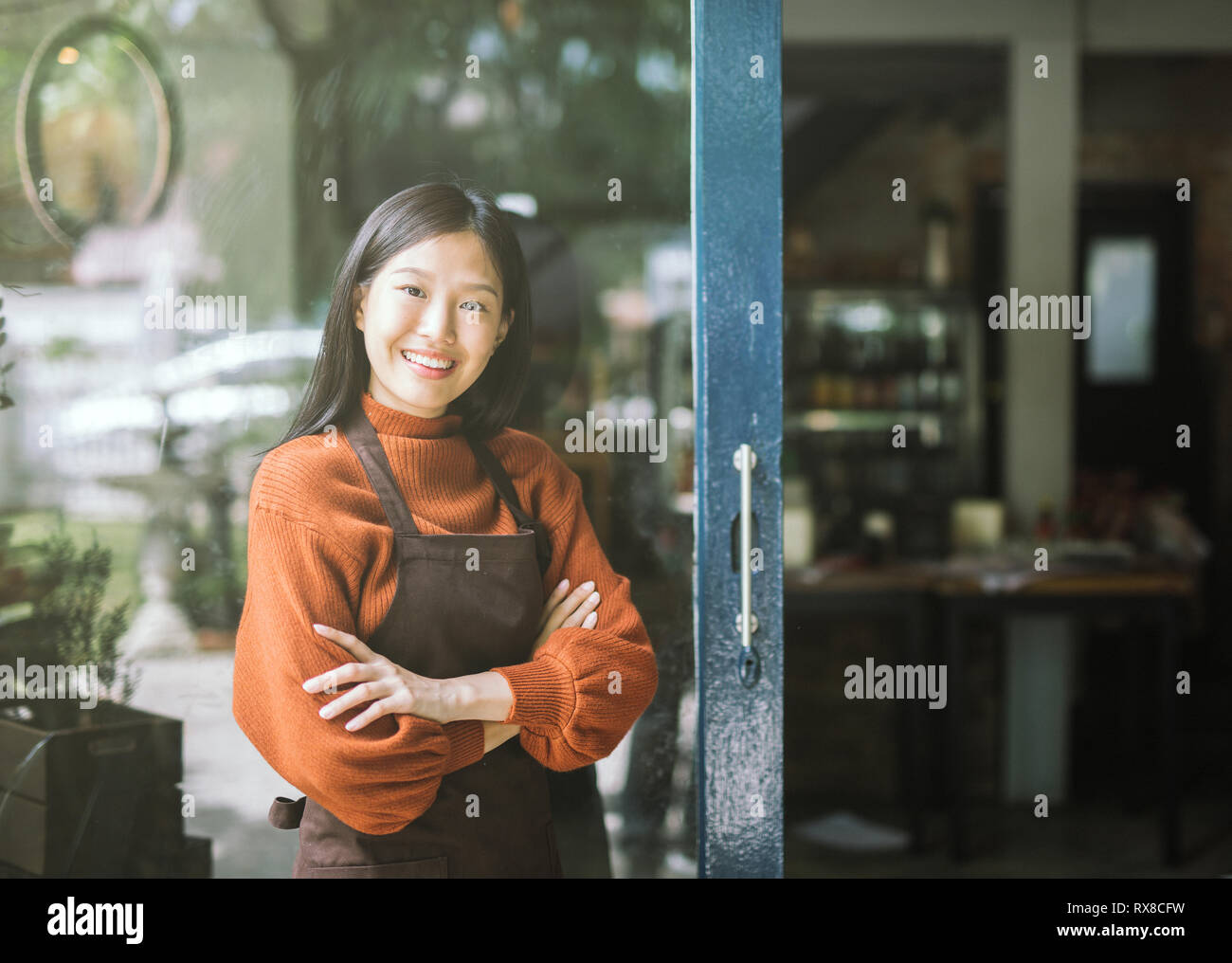 Beautiful asian woman store owner with standing in the doorway of her ...