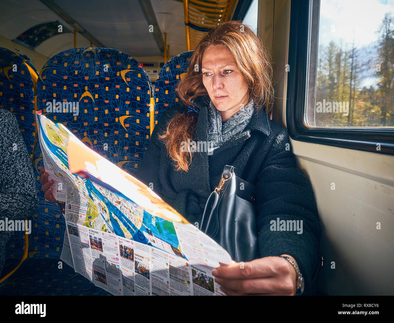 Woman analyzing map while traveling in train Stock Photo - Alamy