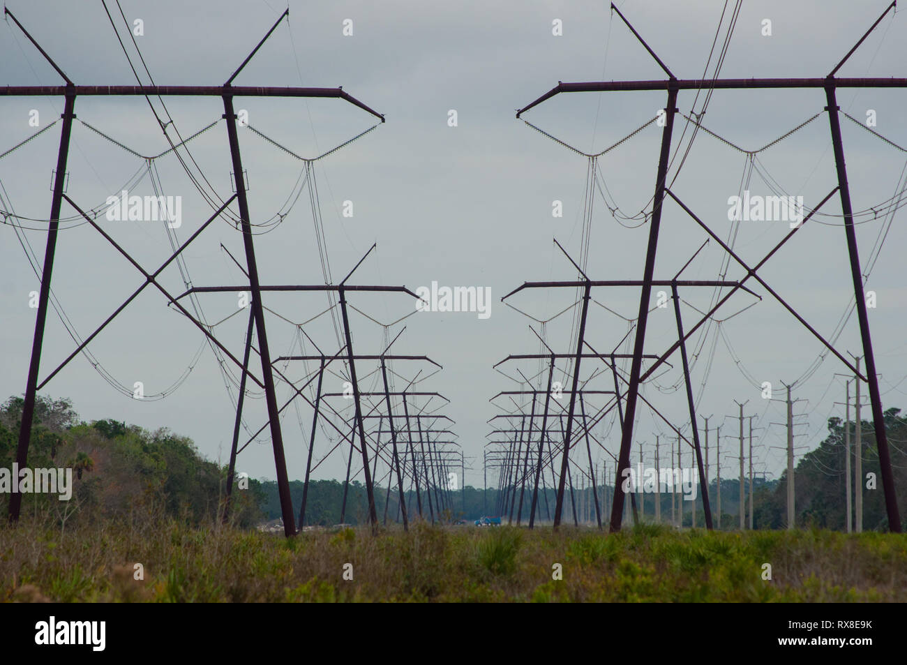 field of electric power cable towers in a line and cloudy sky Stock ...