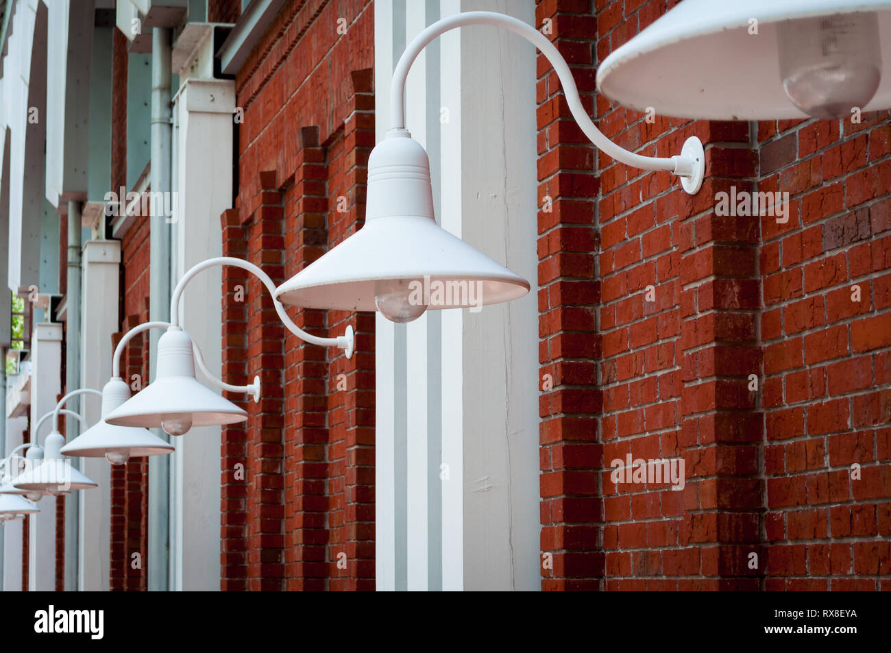 Perspective white hanging lamps from brick wall and wooden columns ...