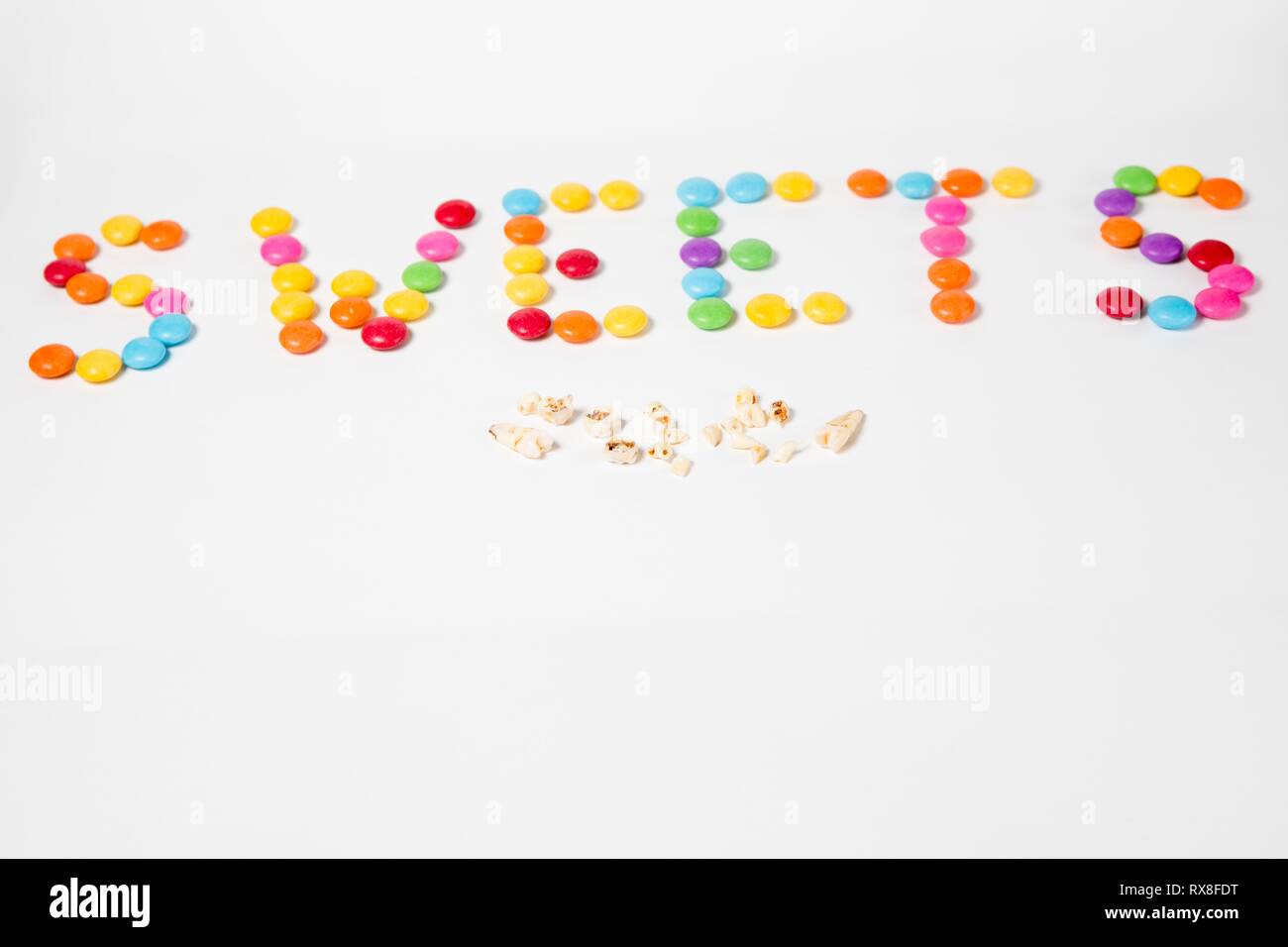 Inscription SWEETS made from colorful sweet candies and caries on teeth ...