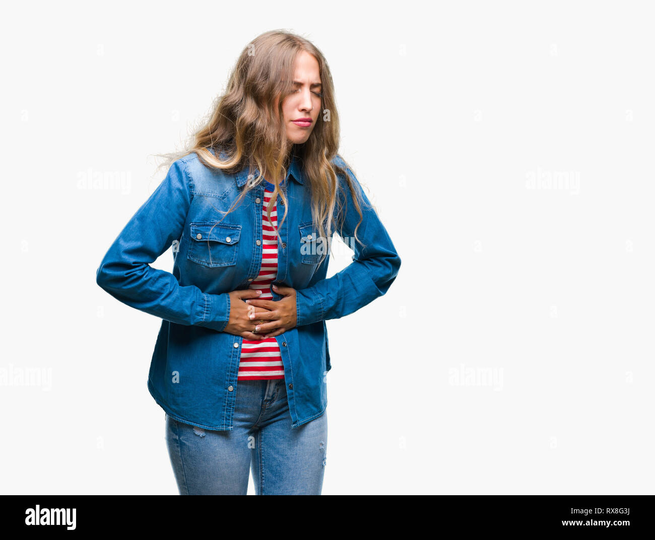 Beautiful young blonde woman over isolated background with hand on ...