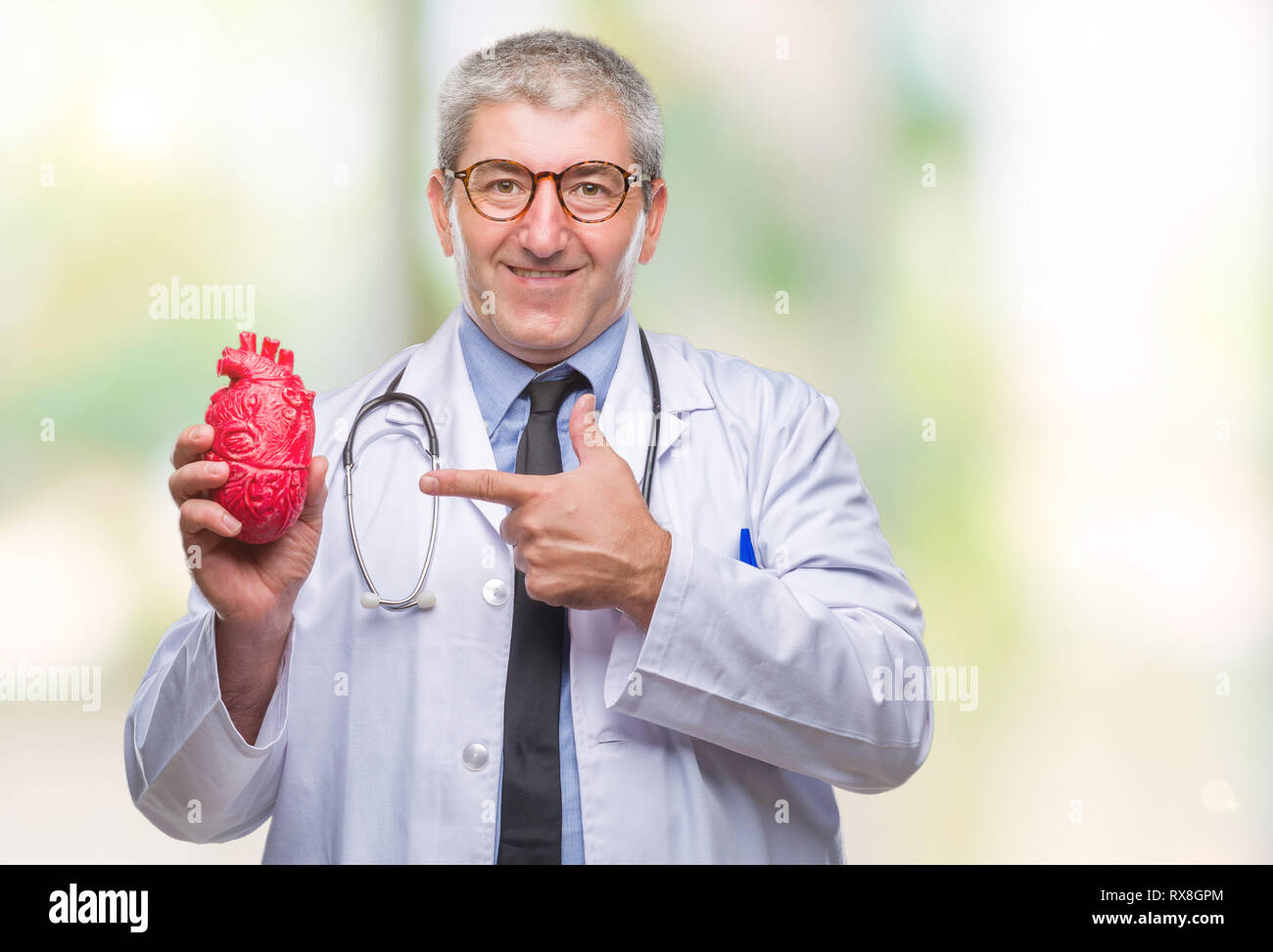 Handsome senior cardiologist doctor man holding heart over isolated ...