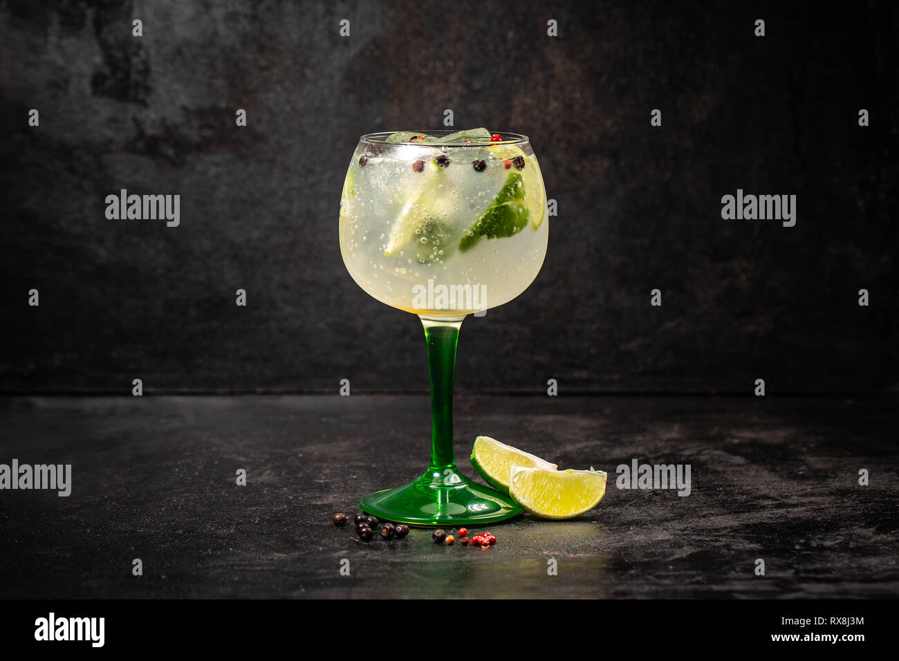 Glass of gin tonic with mint, lime and ice on dark background Stock ...