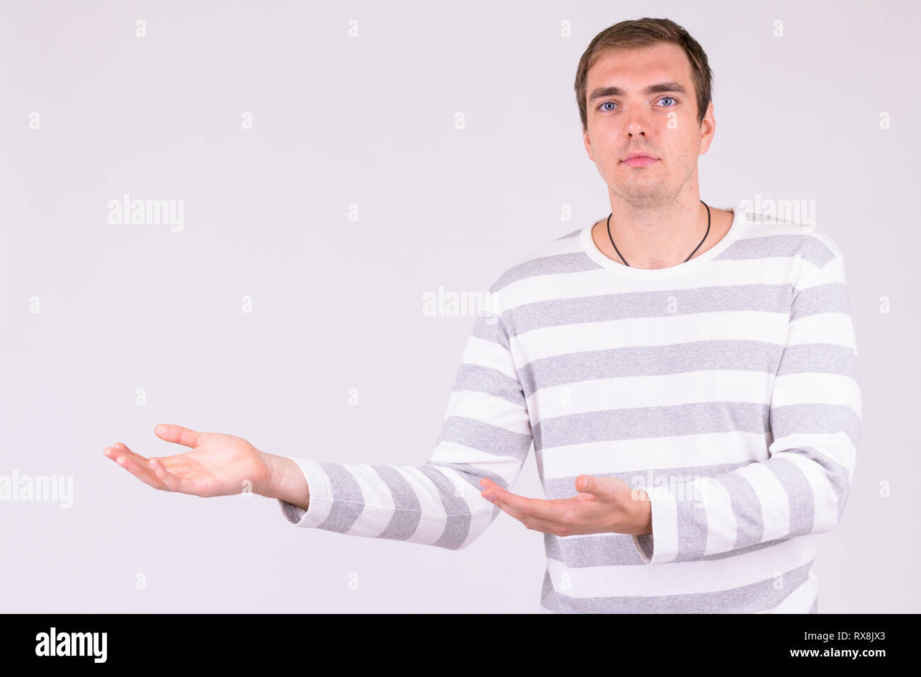Portrait of man showing something against white background Stock Photo ...