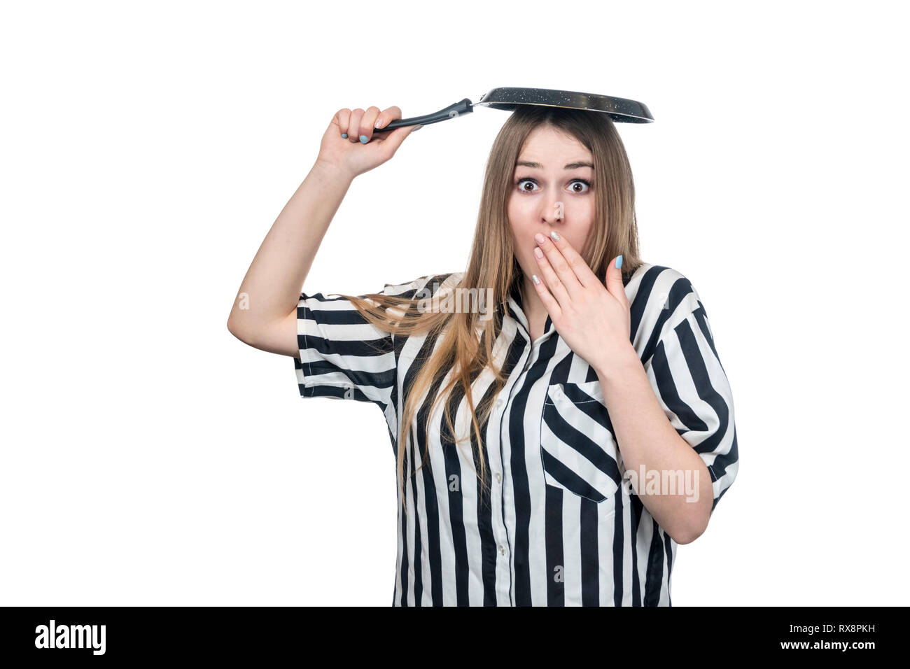 surprised woman covers her mouth with a frying pan on her head ...