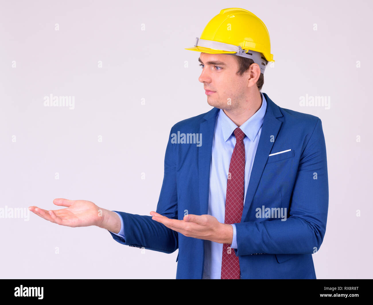 Portrait of businessman as engineer thinking and showing something ...