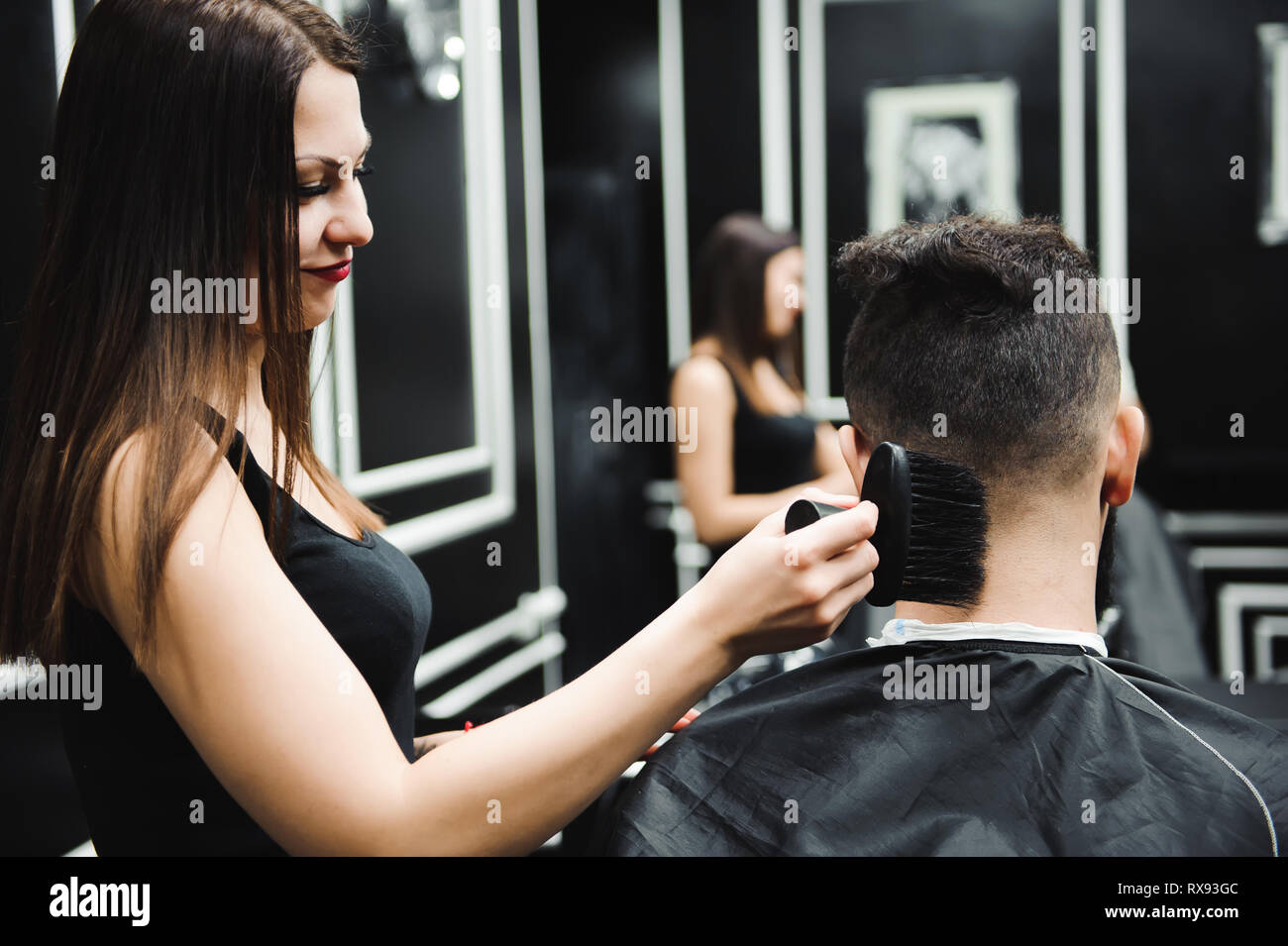 Master cuts hair and beard of men in the barbershop, hairdresser makes ...