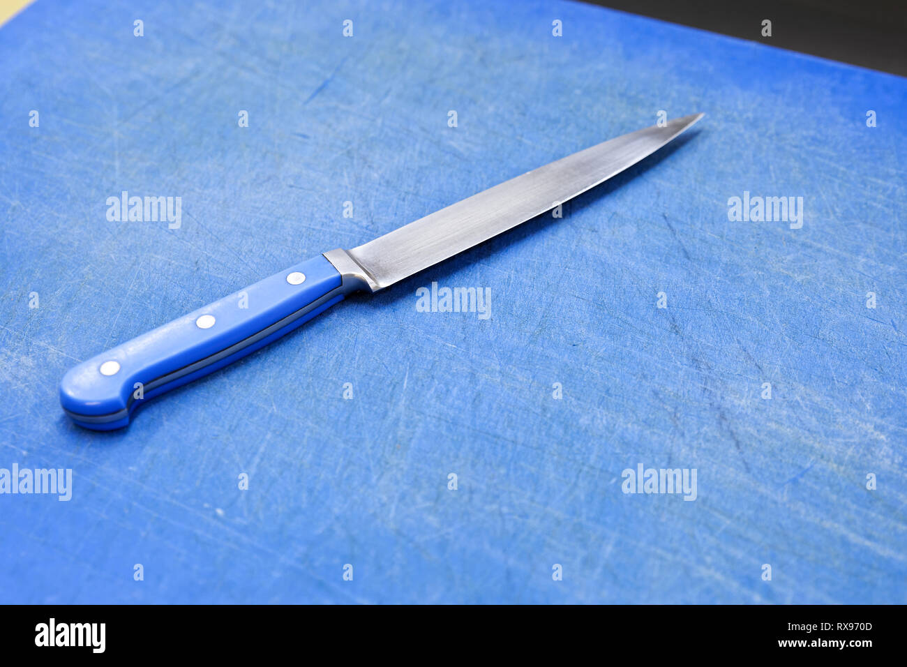 Kitchen knife with plastic blue handle lying on plastic blue chopping ...