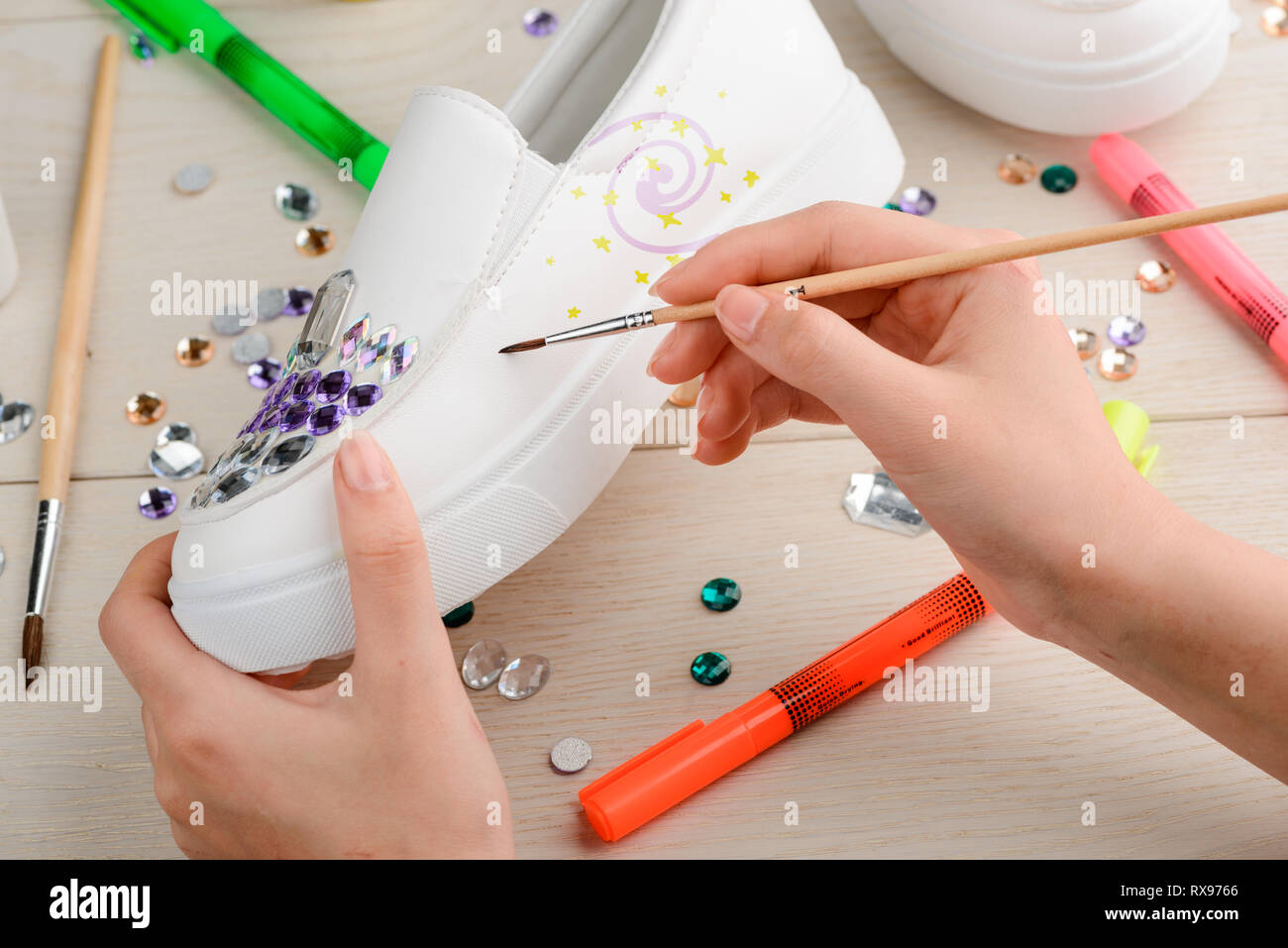 Girl painting stars on shoes Stock Photo - Alamy