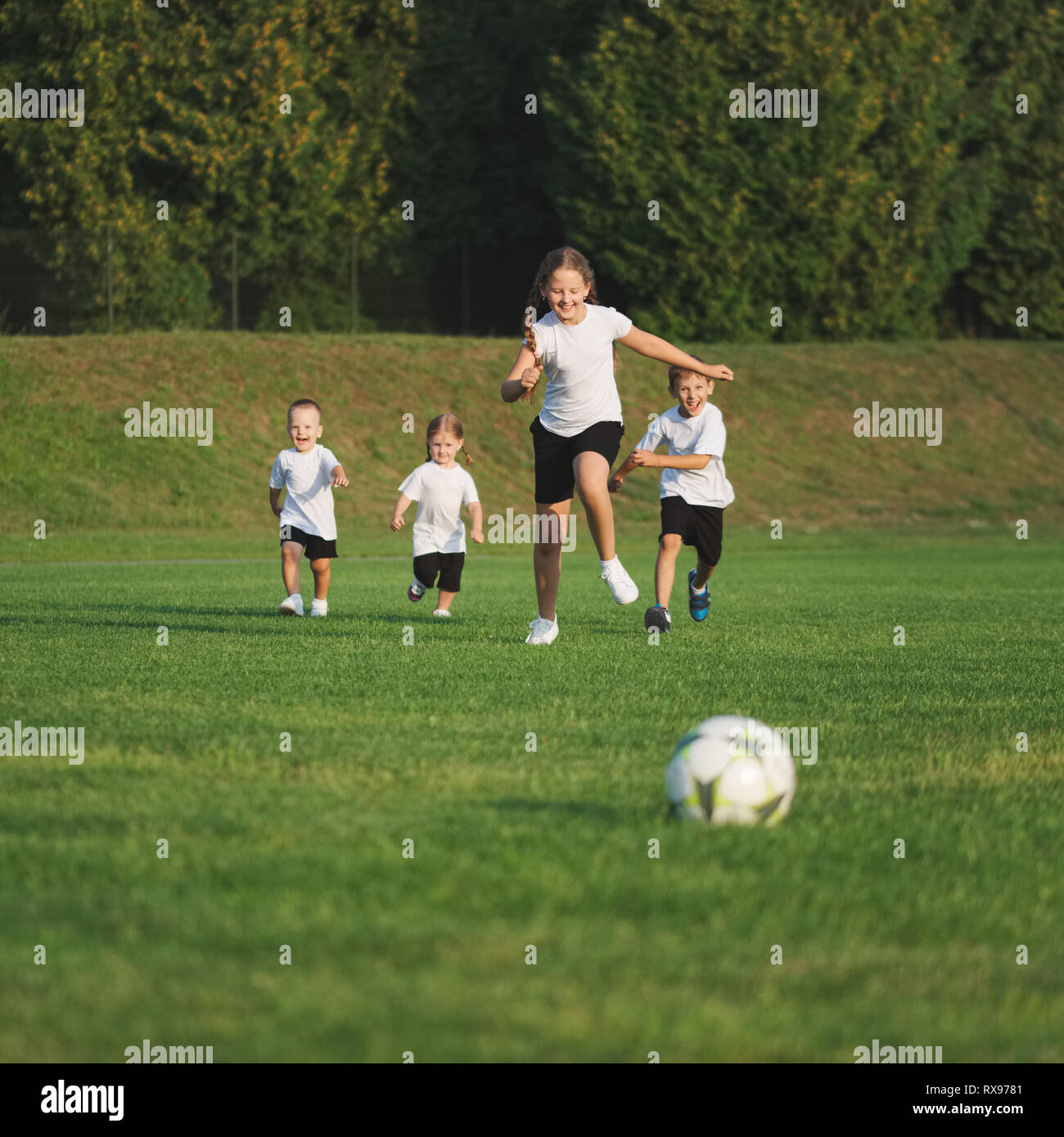 little happy children on football field Stock Photo - Alamy