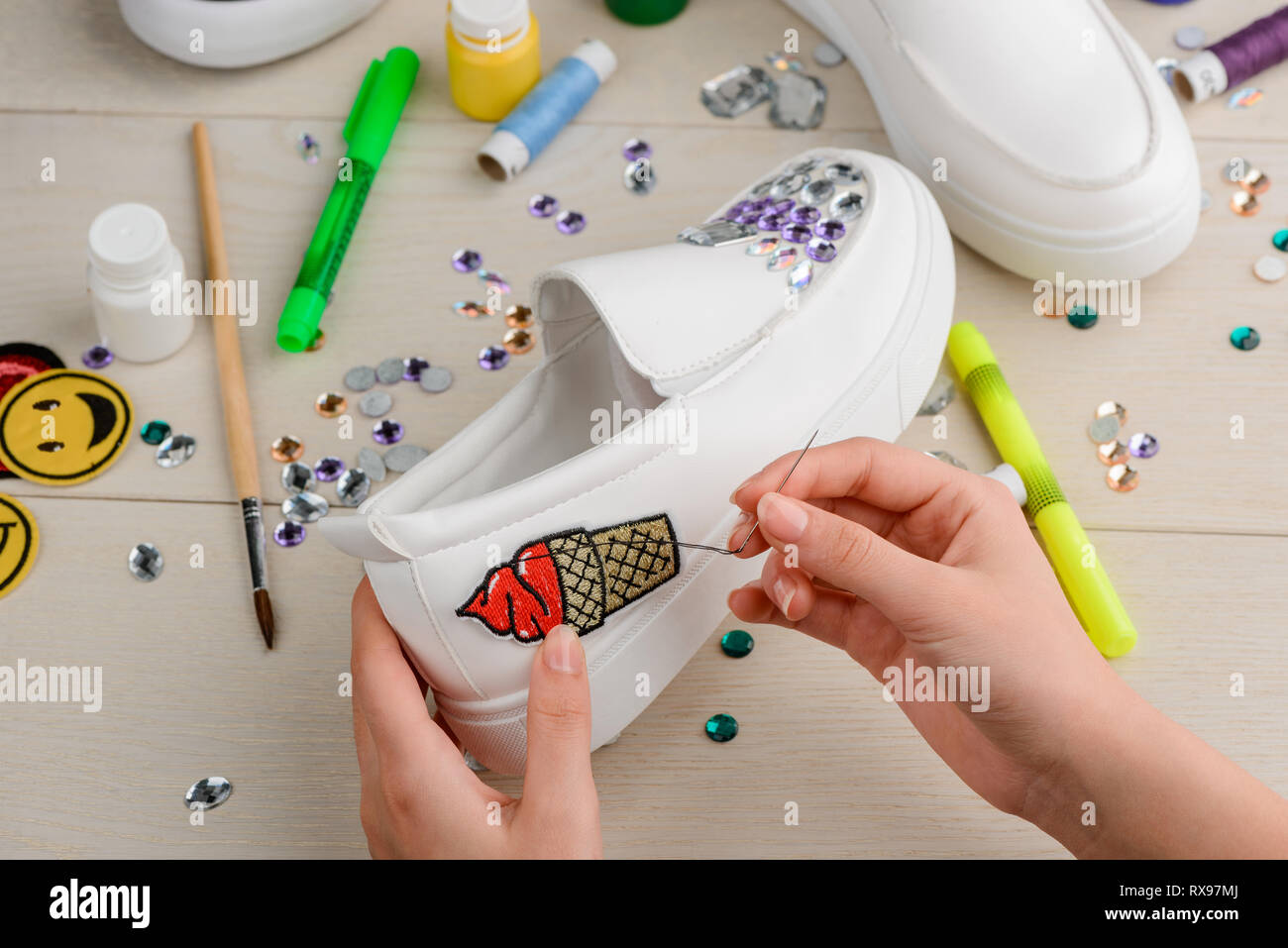 Girl customizes her white shoes Stock Photo - Alamy