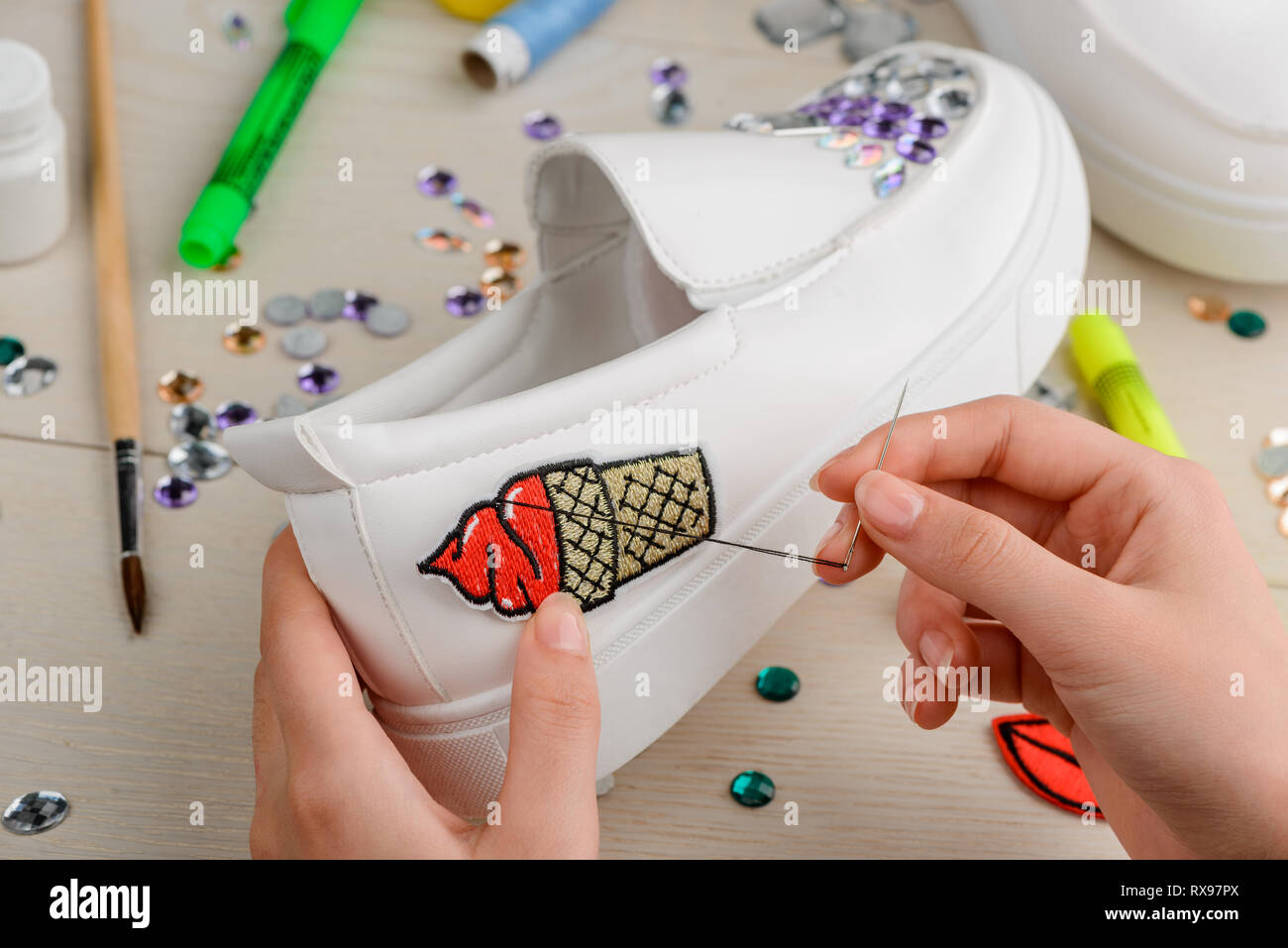 Woman sewing an embroidery patch Stock Photo - Alamy