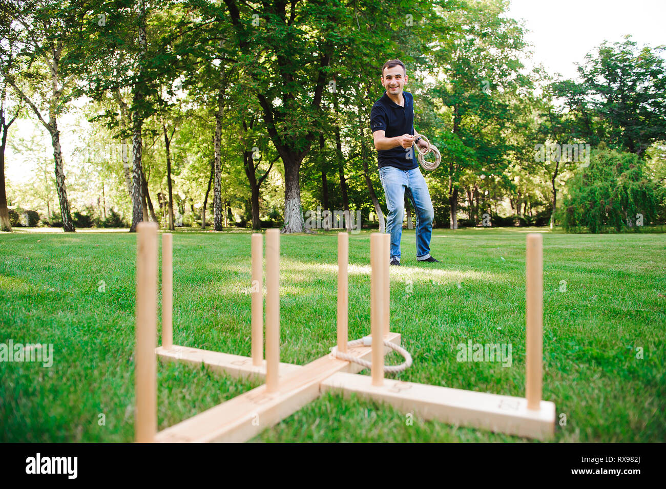 Outdoor games - guy playing ring toss in a park Stock Photo - Alamy