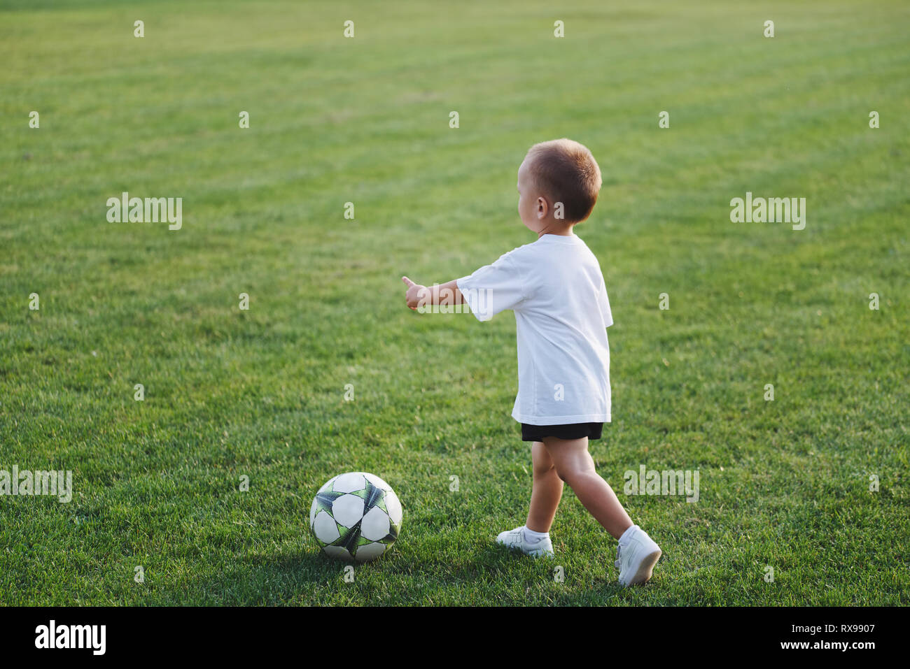 little happy boy on football field Stock Photo - Alamy