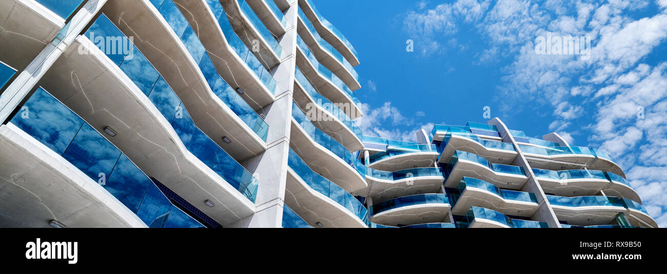 Cropped horizontal image modern blue glass apartments house over cloudy ...