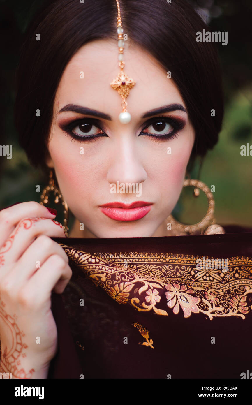 Portrait of beauty Indian model with bright make-up who hiding her face ...